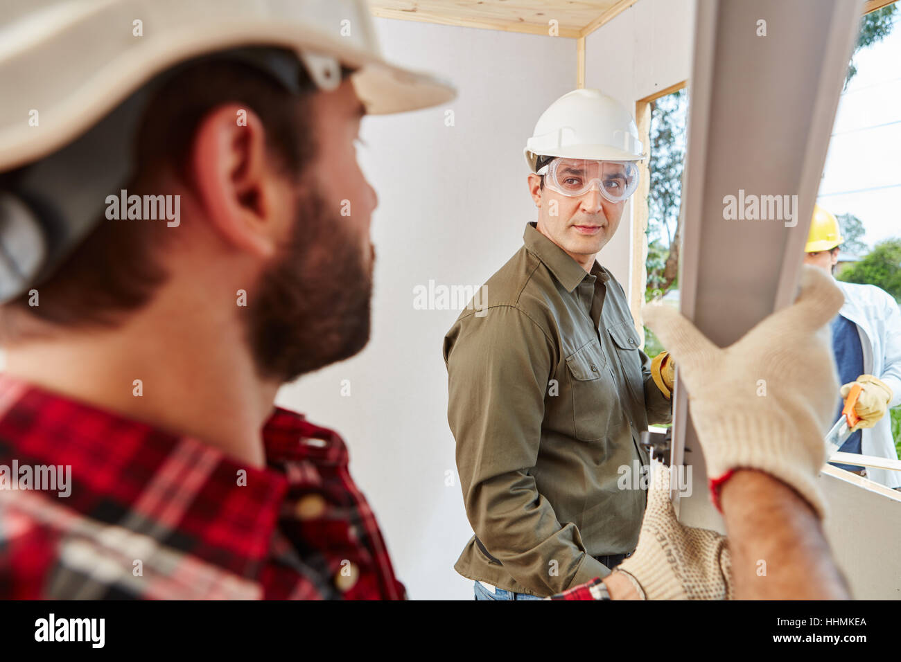 Mechanic team working at construction site installing window Stock ...