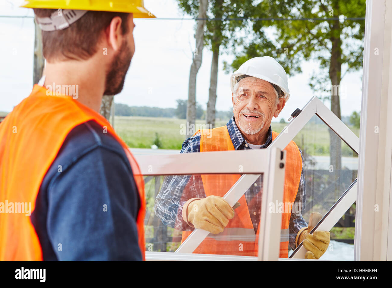 Window builder team working on woodhouse installation Stock Photo - Alamy