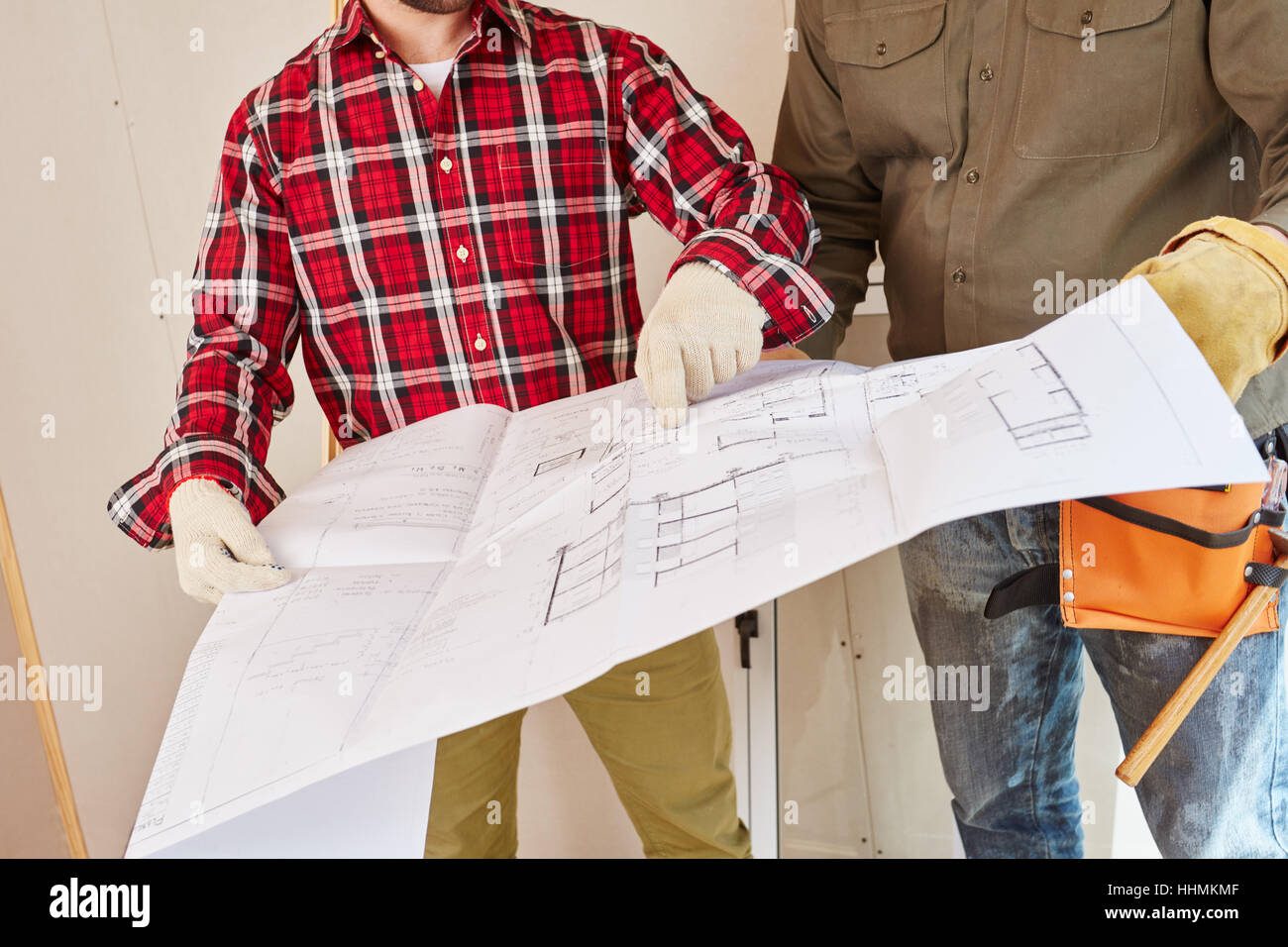 Architects planning new building holding architectural floorplan ...