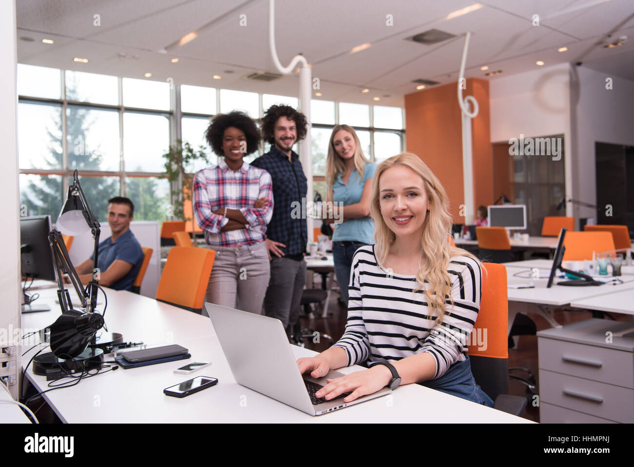 young smiling informal businesswoman working in the office with ...