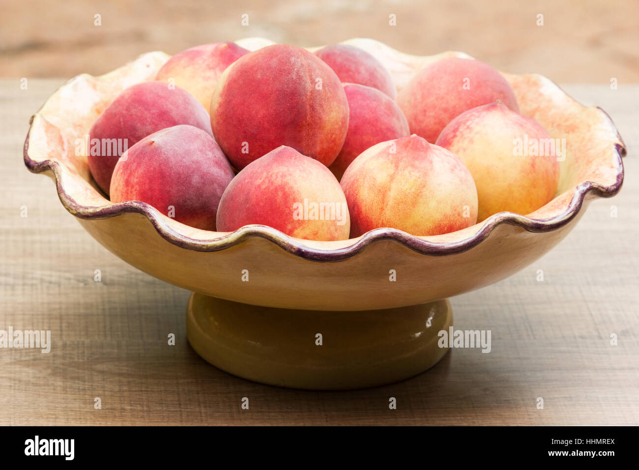 Fresh peaches in a fruit bowl on white background Stock Photo - Alamy