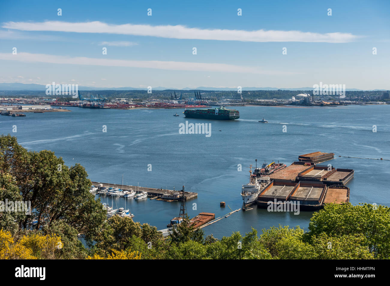 A container ship enter the Port of Tacoma. Barges can be seen in the ...