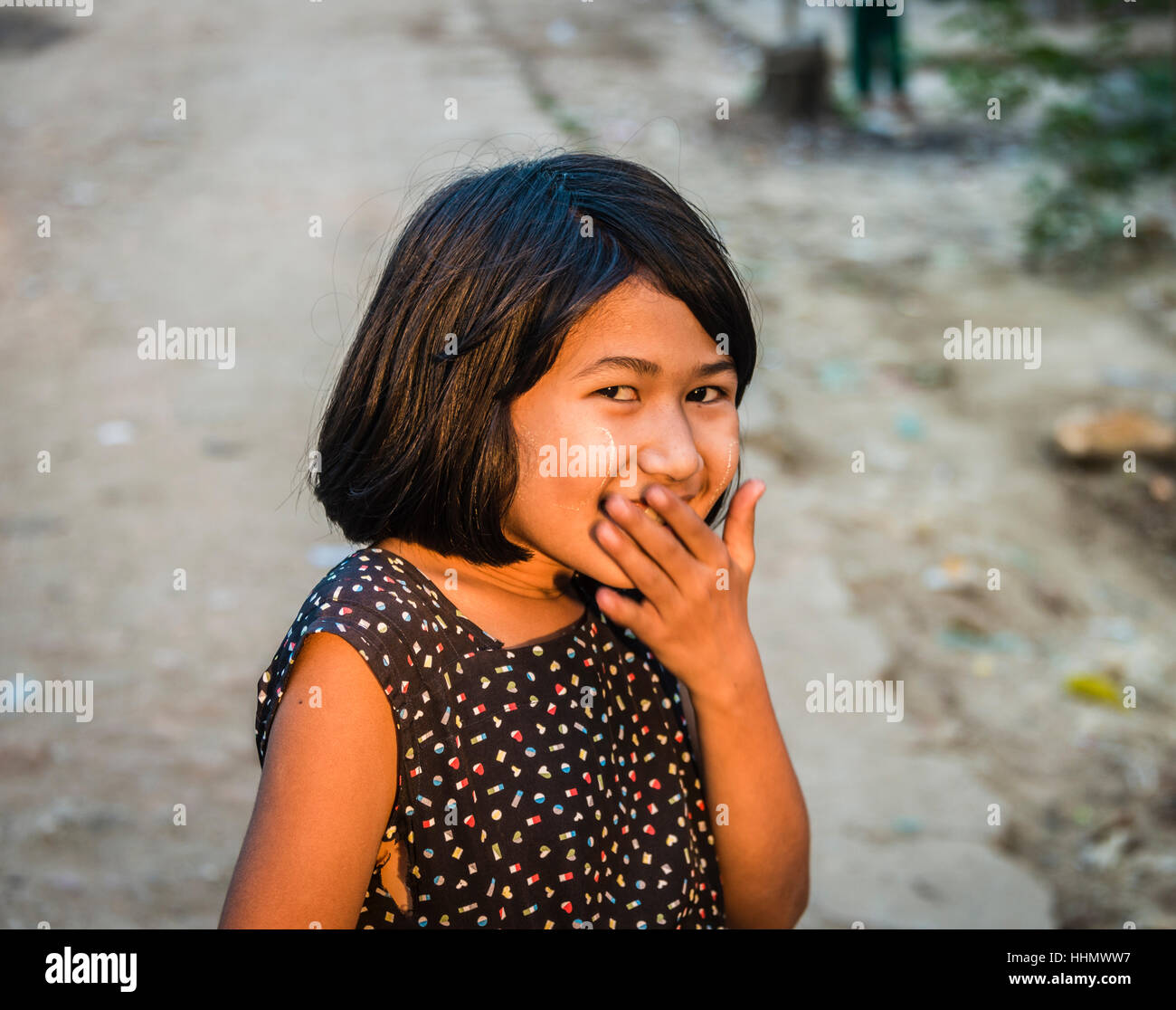 Little native girl smiling mischievously, portrait, Yangon, Myanmar ...