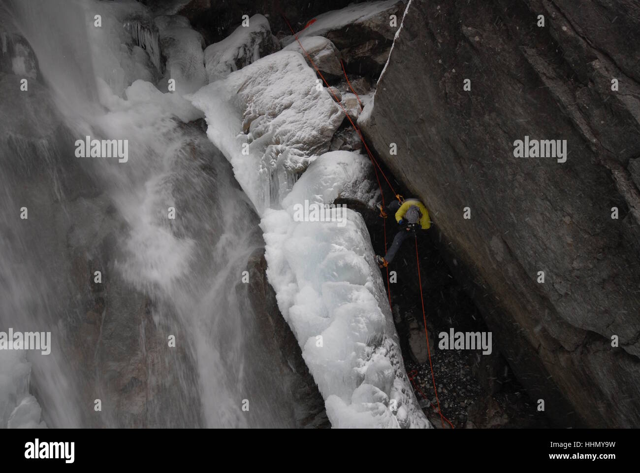 Photographer suspended on fixed ropes securing himself in place in ...