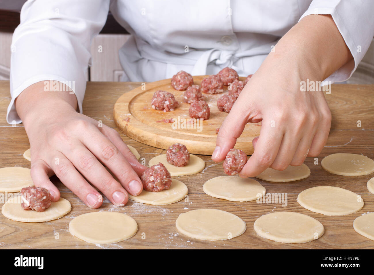 Cook hands closeup lay out meat balls on dough rounds Stock Photo - Alamy