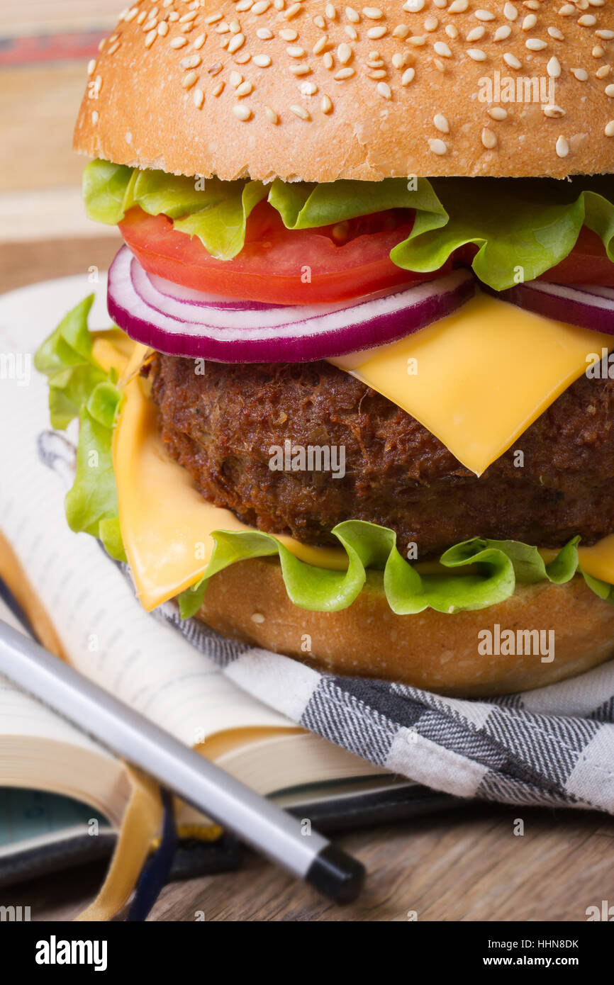 School lunch: fresh hamburger with meat and cheese. Notepads on the ...