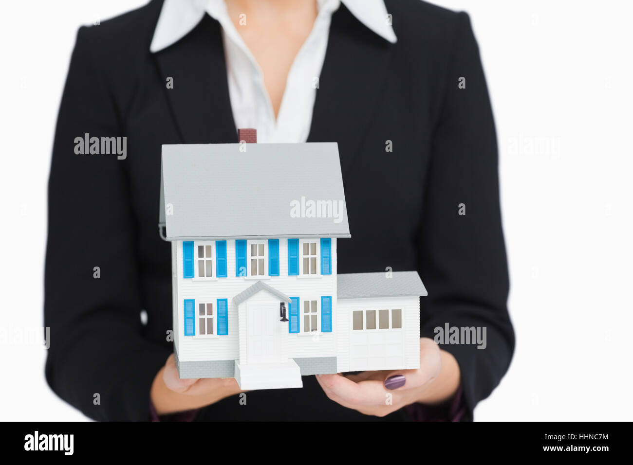 Real estate agent holding a model house against white background Stock ...