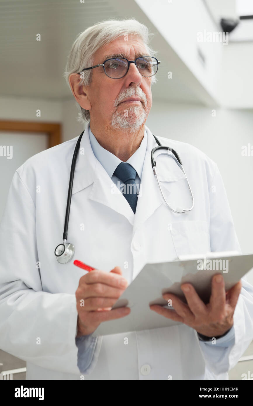Doctor hlding patient file and looking up in hospital corridor Stock ...