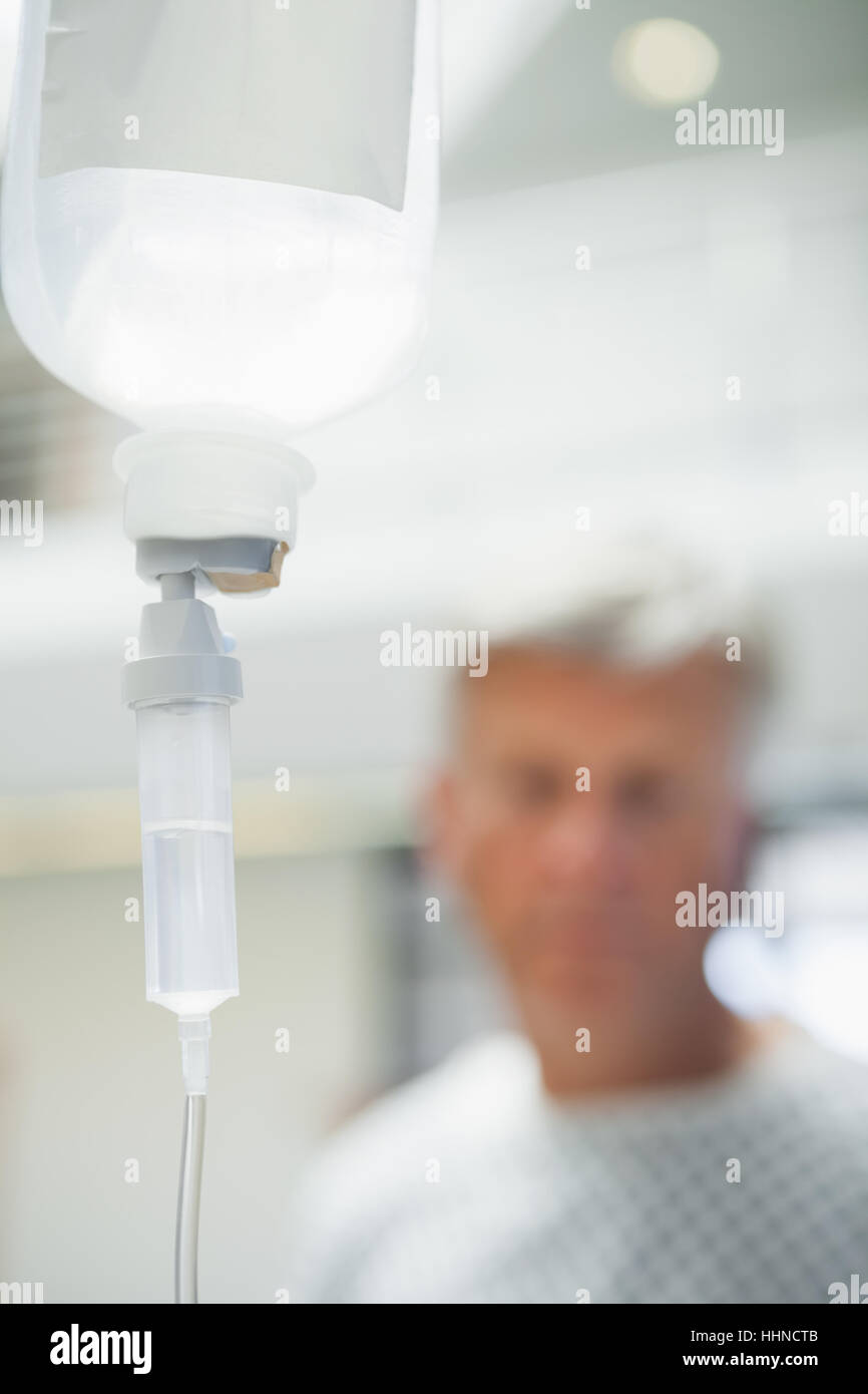 Intravenous drip with patient in background in hospital Stock Photo - Alamy