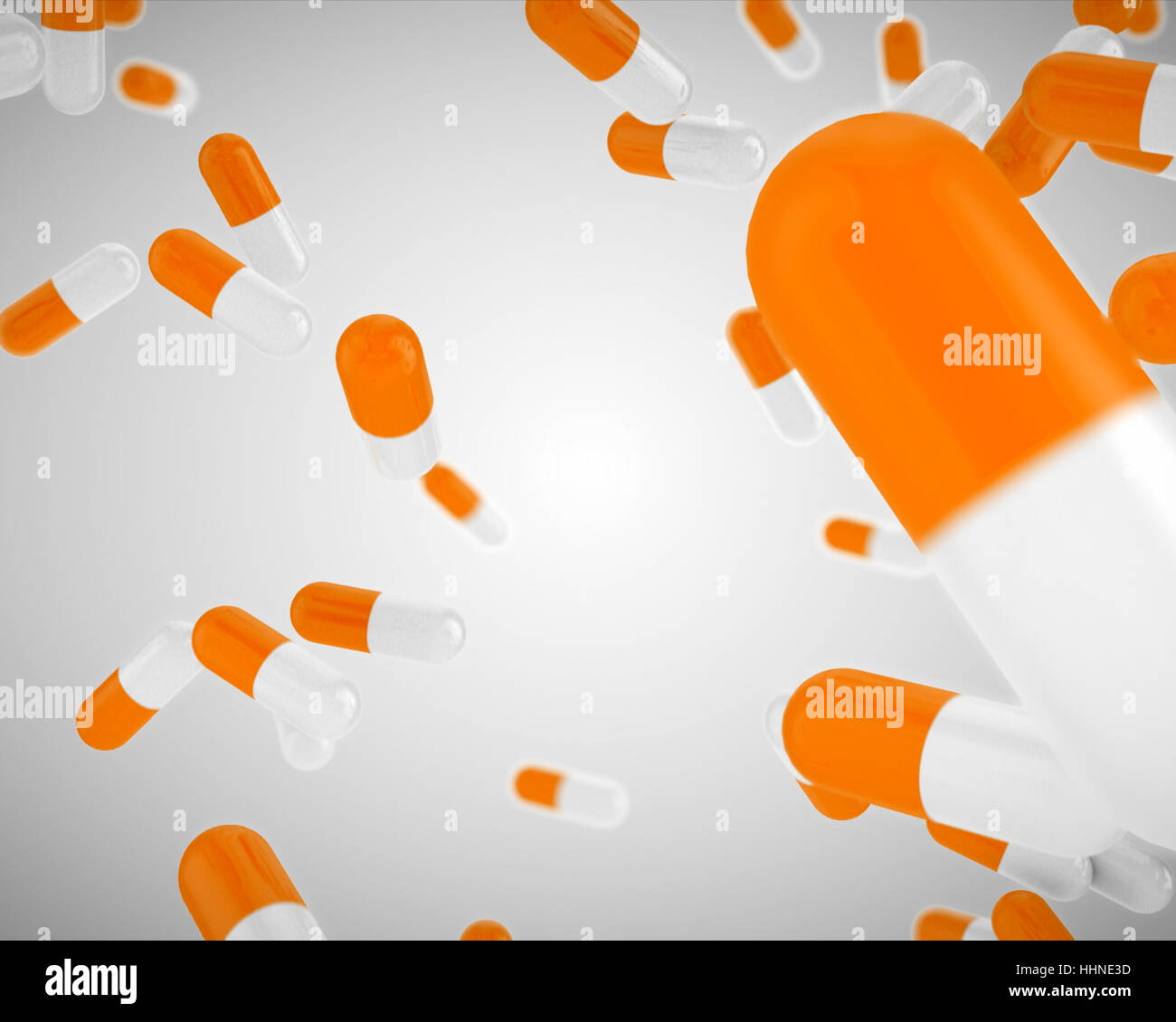 Floating orange pills on grey background Stock Photo - Alamy
