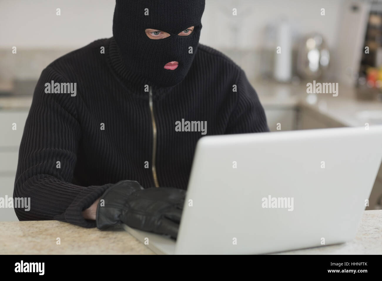 Stranger hacking an unknown laptop and sitting in a kitchen Stock Photo ...
