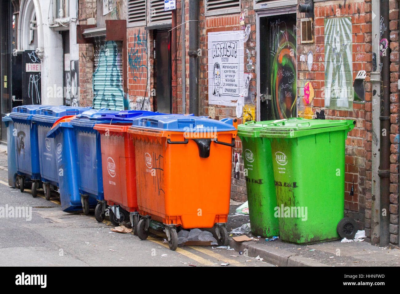 A line of multicoloured dumpsters, Commercial wheelie bins behind ...