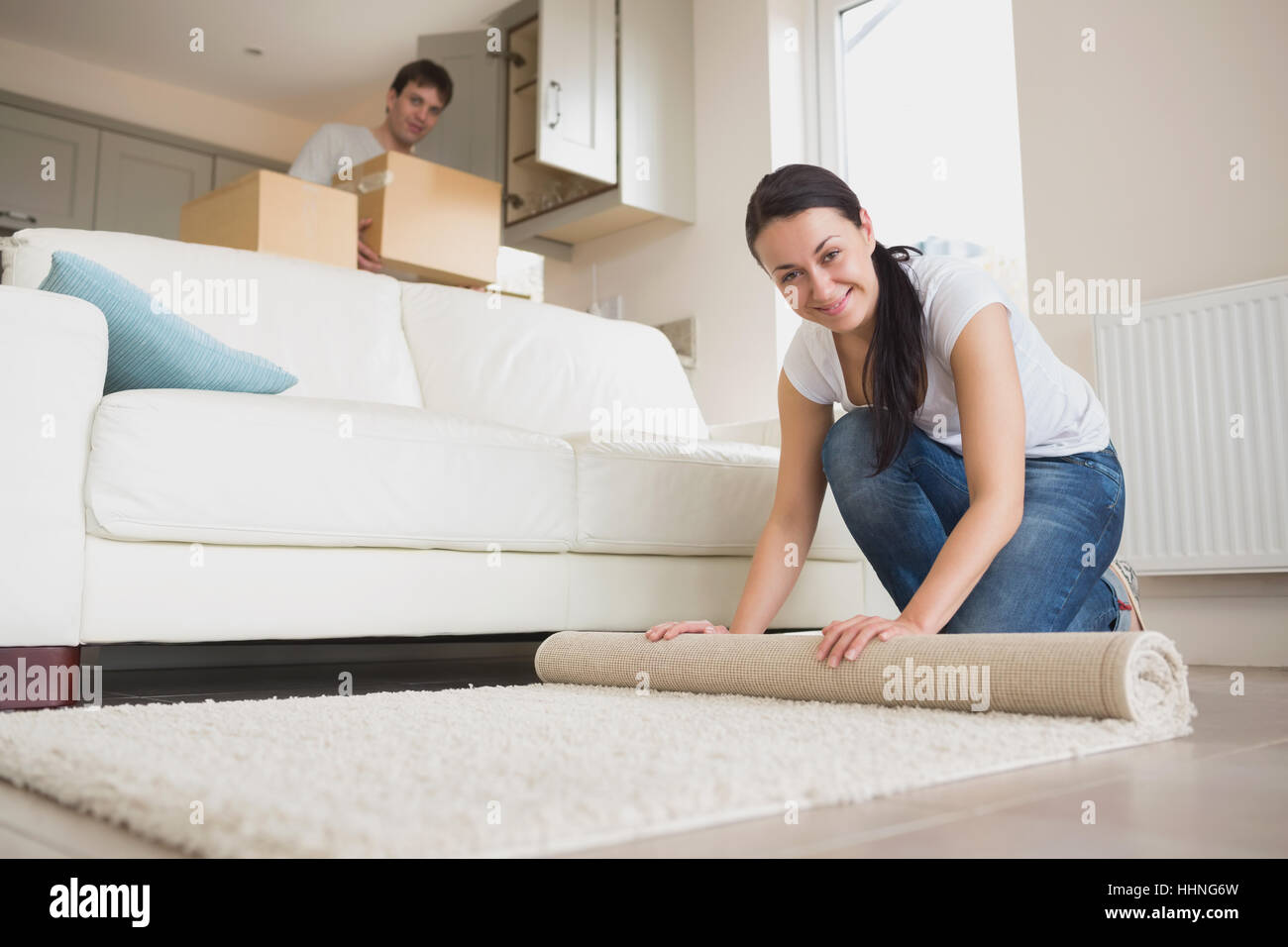 Two young people furnishing the living room of new home Stock Photo - Alamy