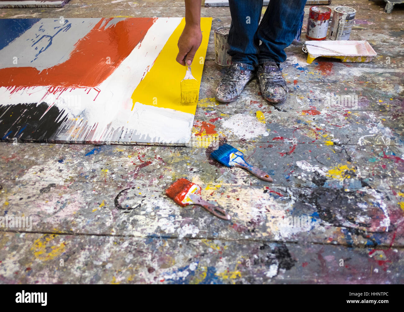 Legs of Mari man painting canvas on floor Stock Photo - Alamy
