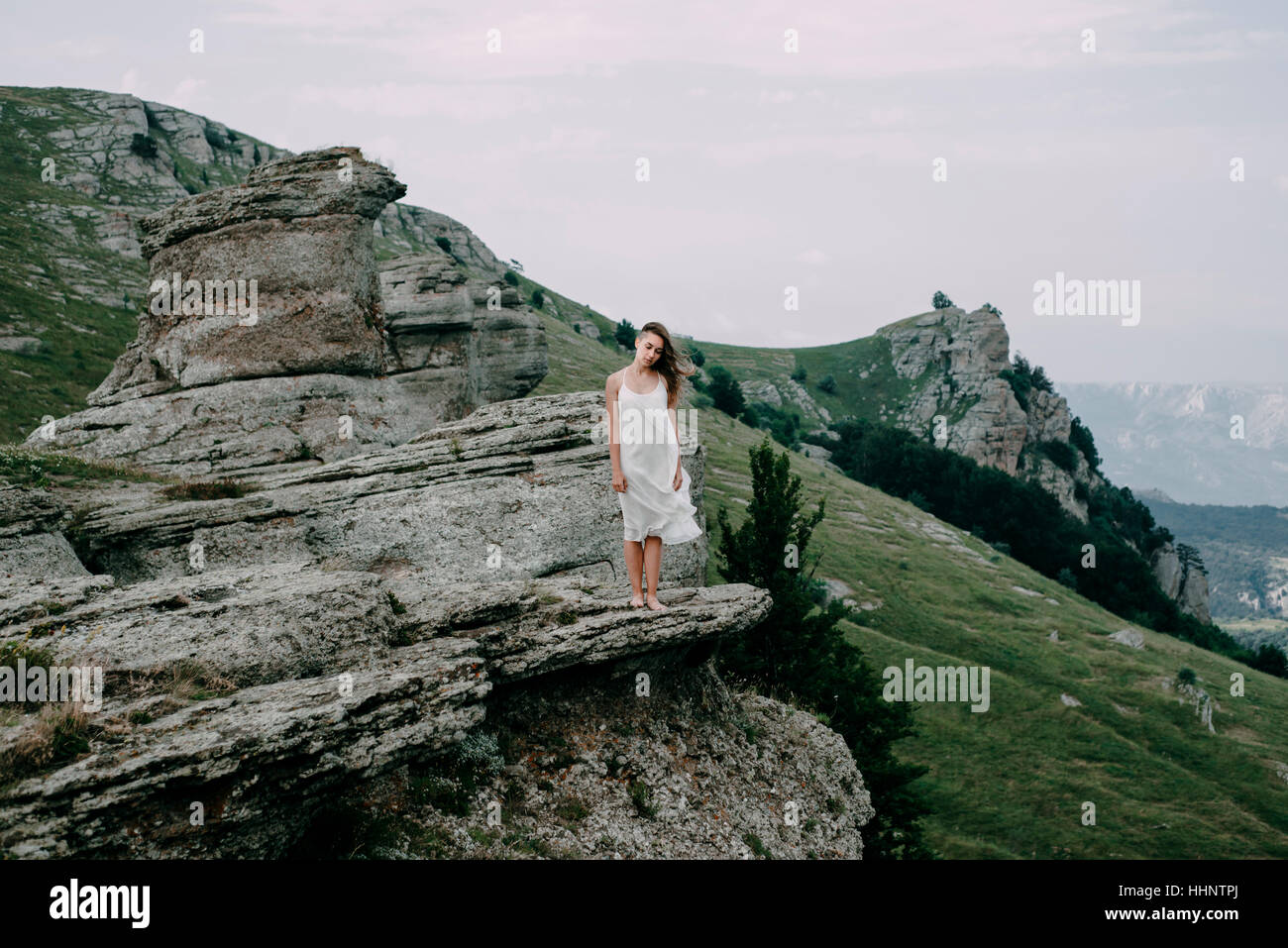 Caucasian woman standing on rock overlooking landscape Stock Photo - Alamy