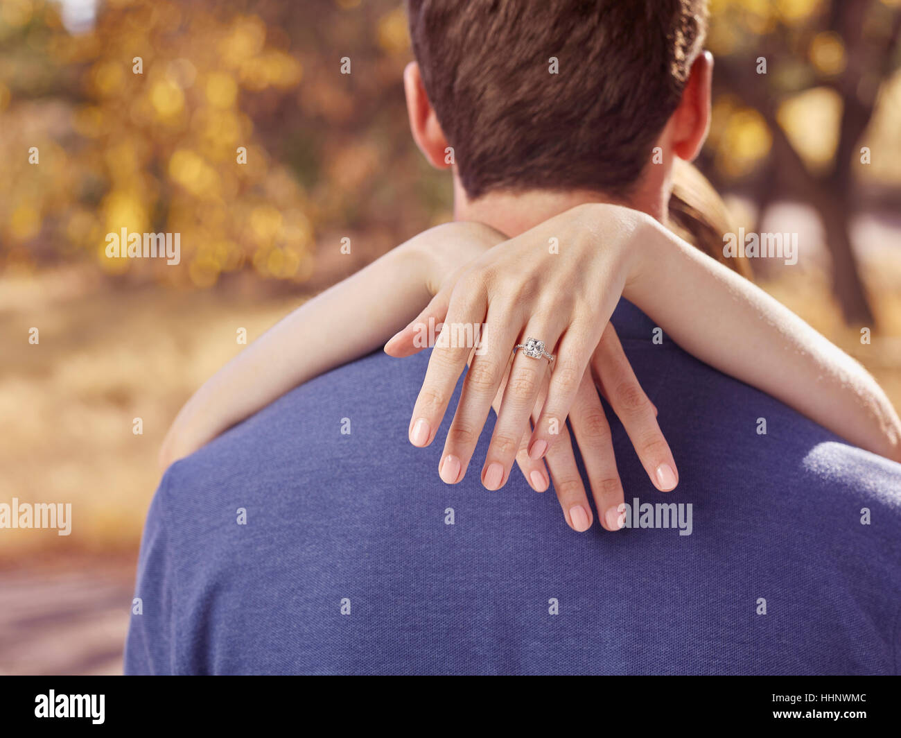 Hands of woman wearing engagement ring hugging man Stock Photo - Alamy