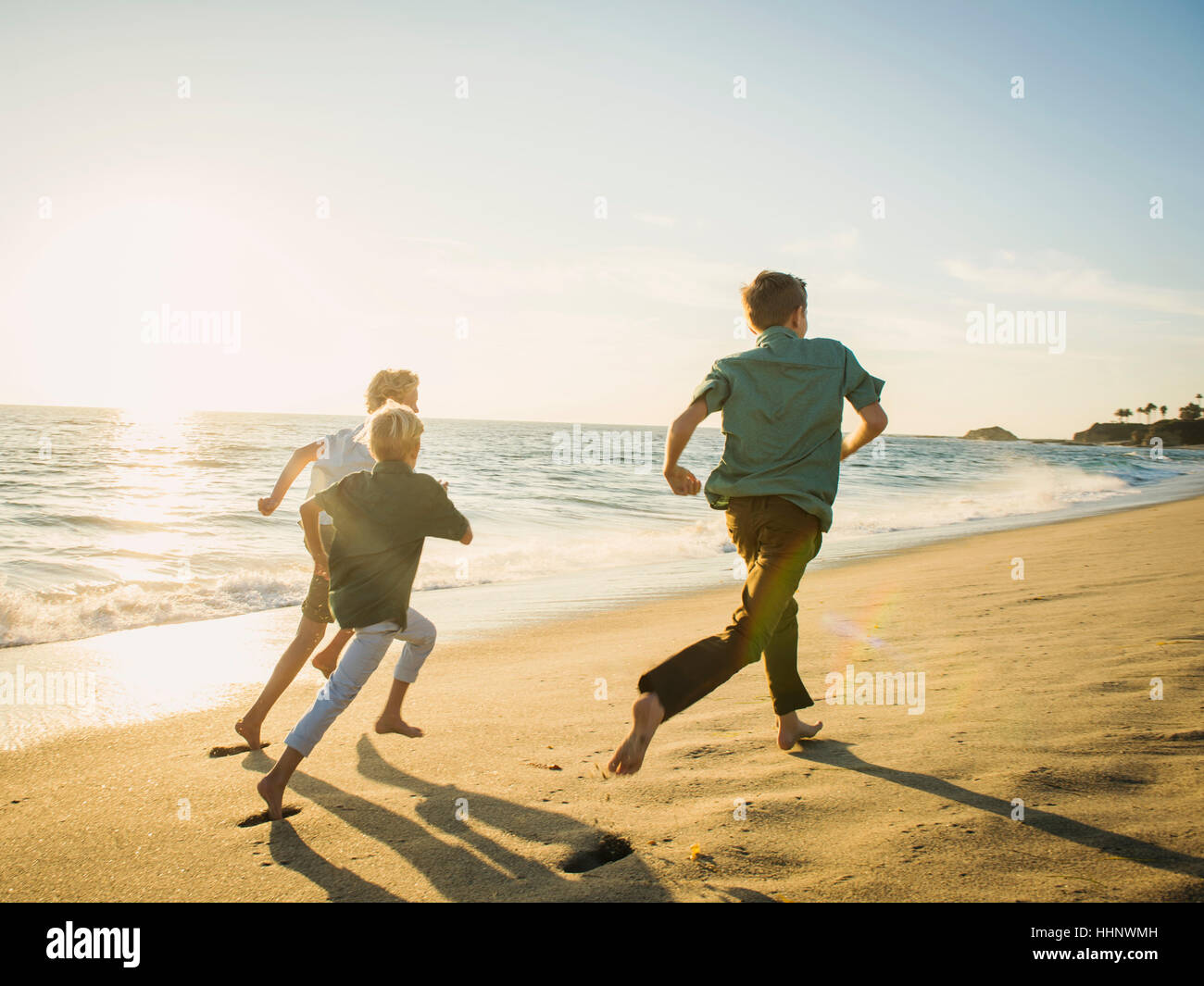 Caucasian brothers running on beach Stock Photo - Alamy