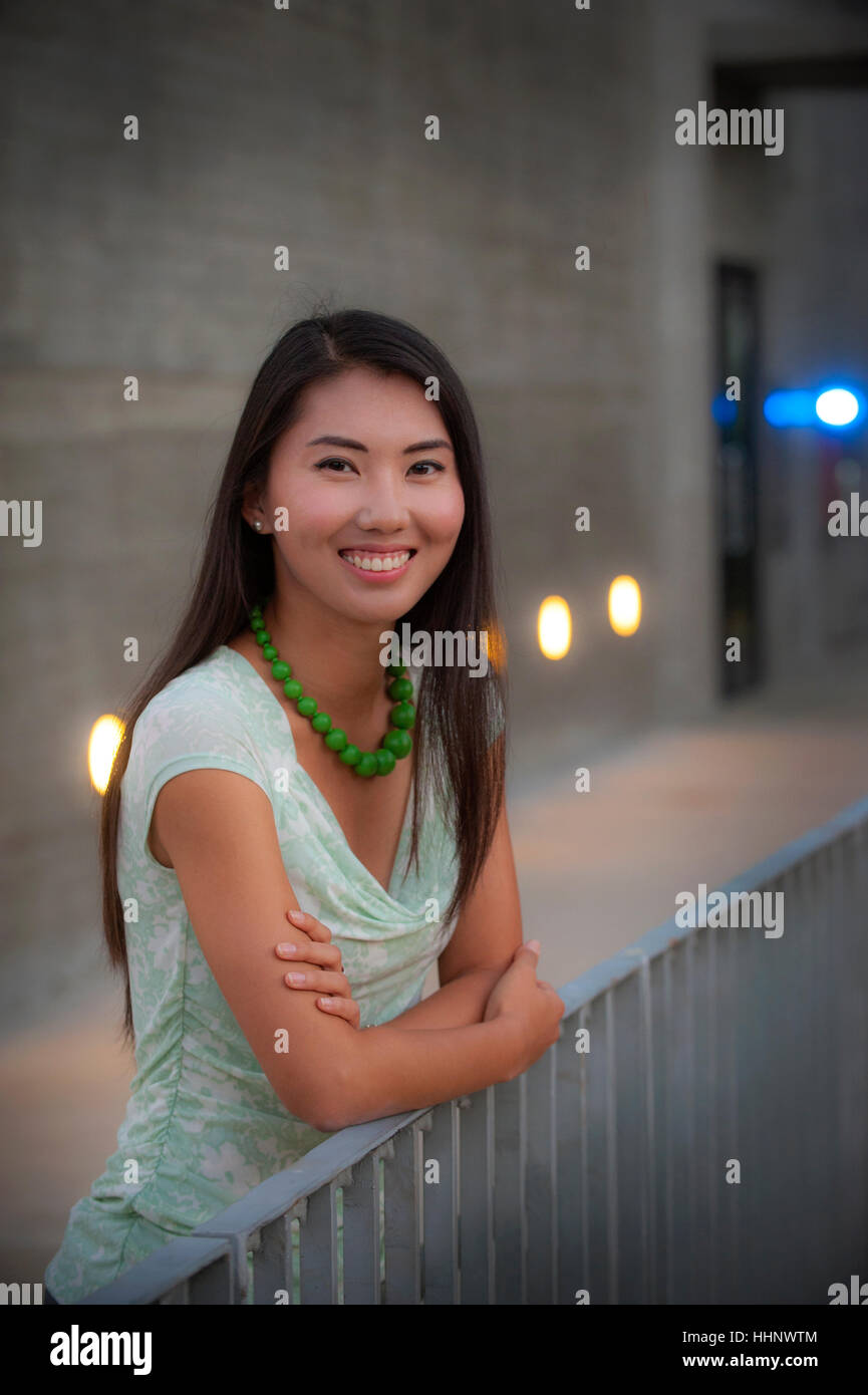 Portrait of smiling woman leaning on railing Stock Photo - Alamy