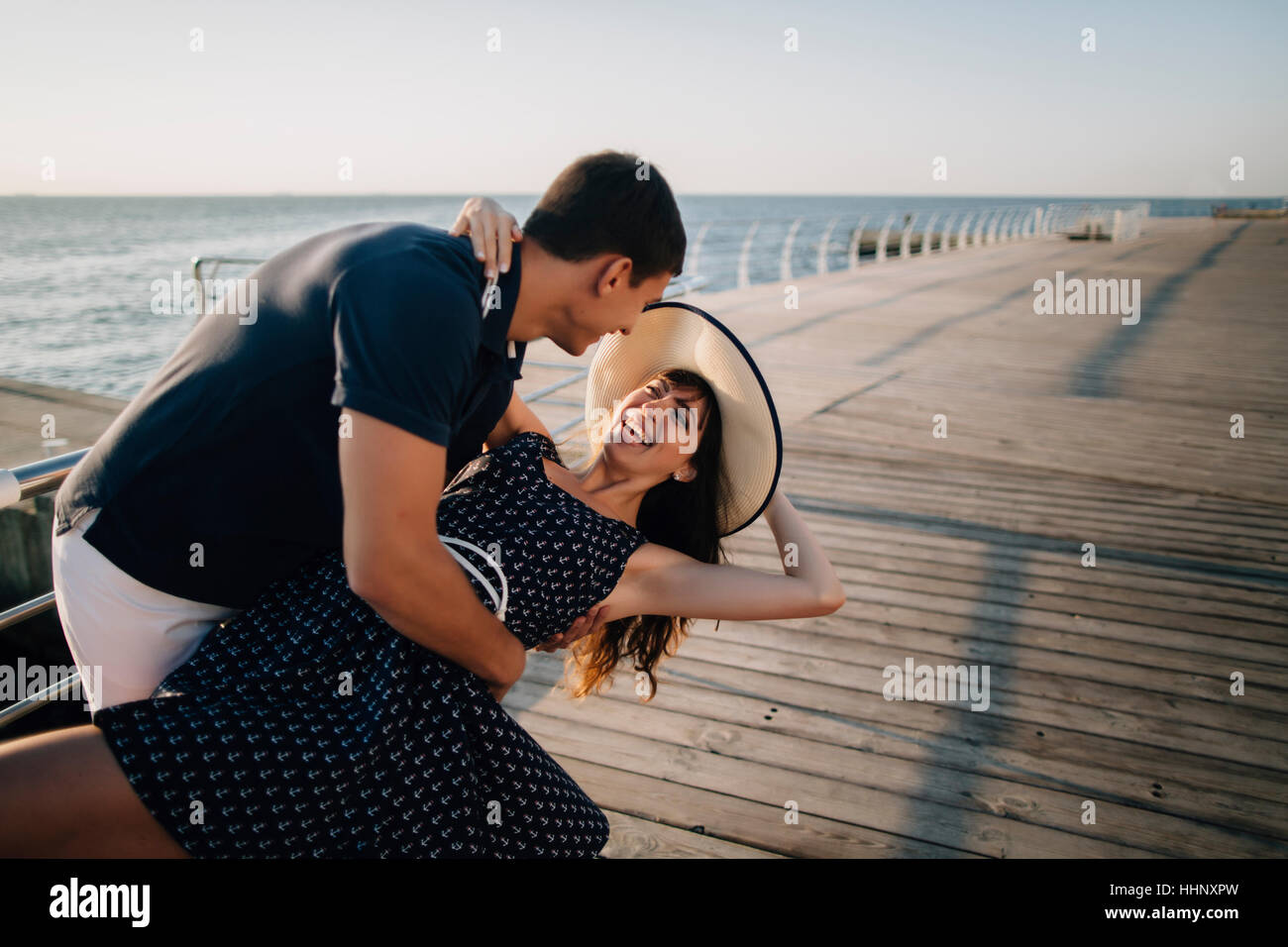 Caucasian man dipping woman at waterfront Stock Photo - Alamy
