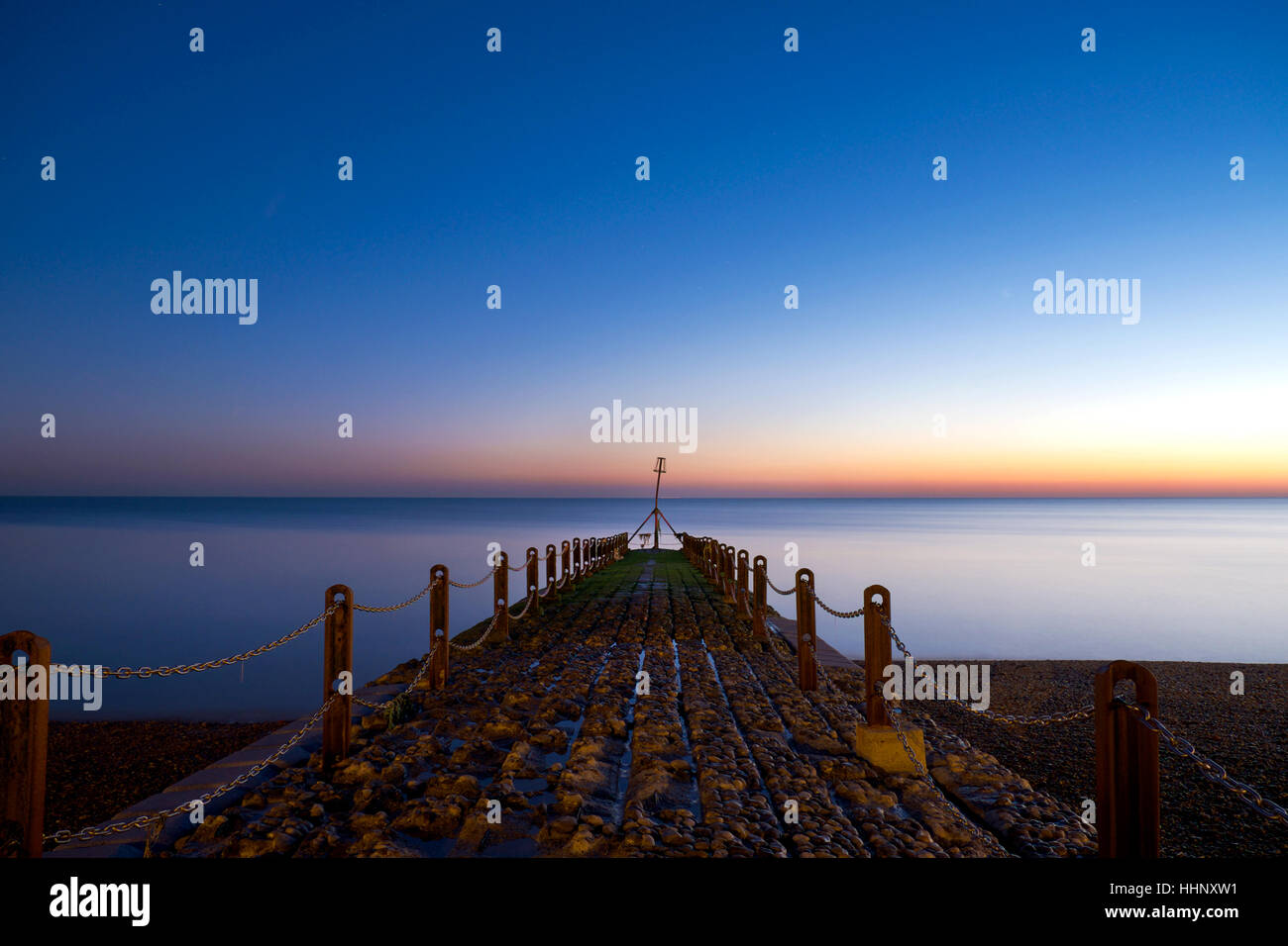 beautiful brick jetty, jutting out to sea at sunset, the sea is calm ...