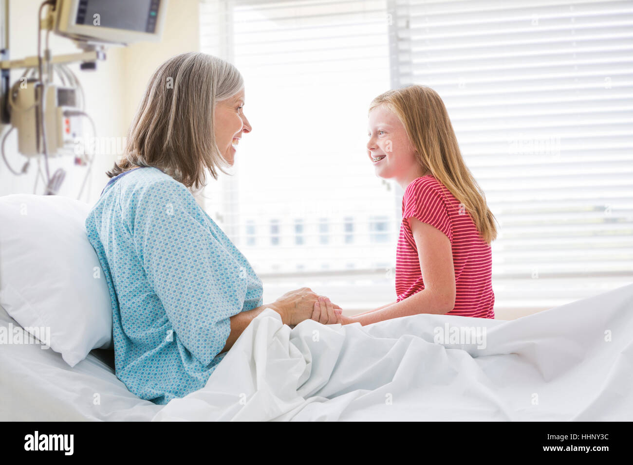 Caucasian granddaughter visiting with grandmother in hospital Stock ...