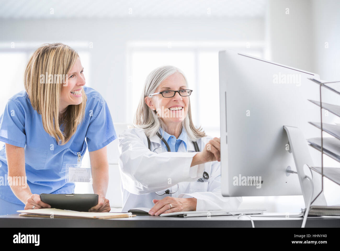 Caucasian doctor and nurse using computer at desk Stock Photo - Alamy