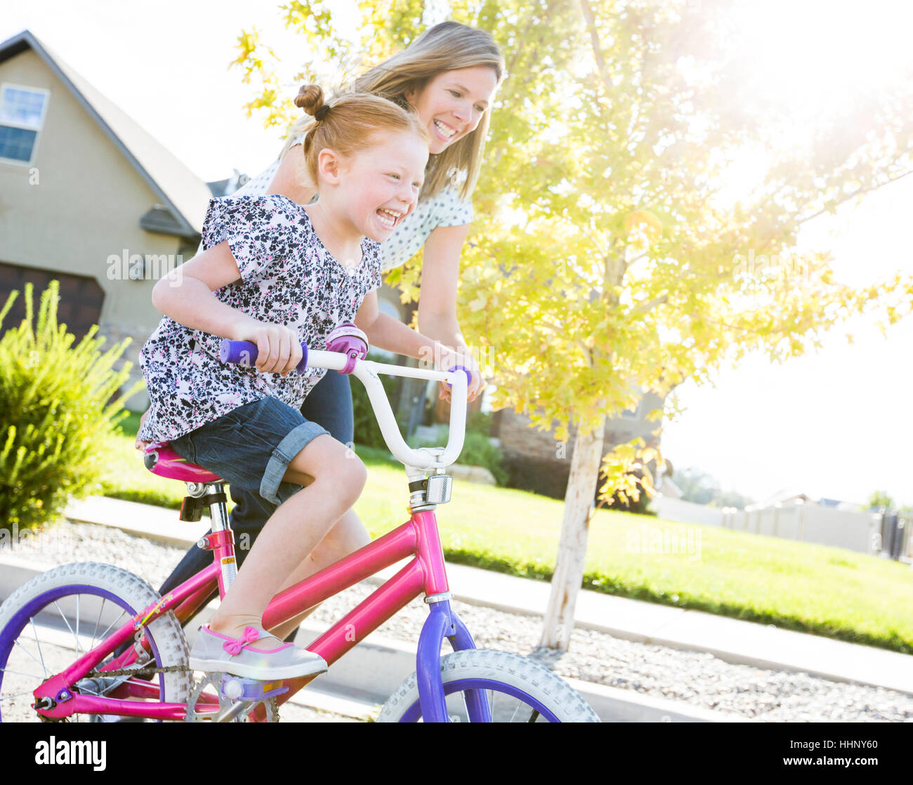 Caucasian mother teaching daughter to ride bicycle Stock Photo - Alamy