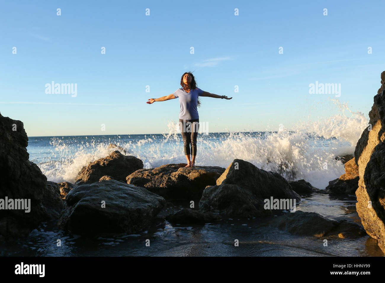 Woman meditating on rock in hi-res stock photography and images - Alamy
