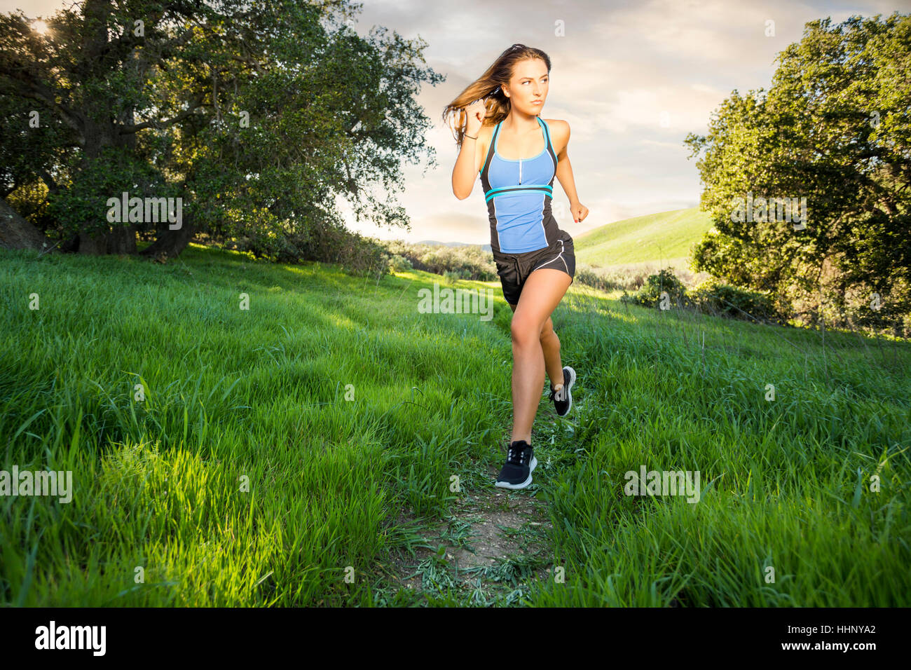 Caucasian woman running on hill Stock Photo - Alamy