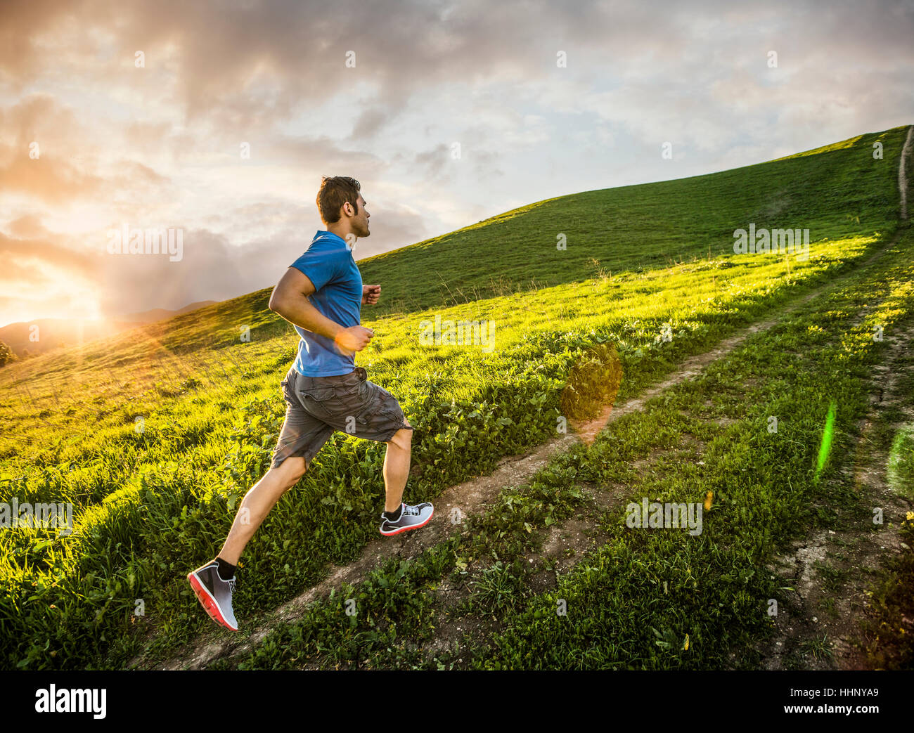 Hispanic man running on hill Stock Photo - Alamy