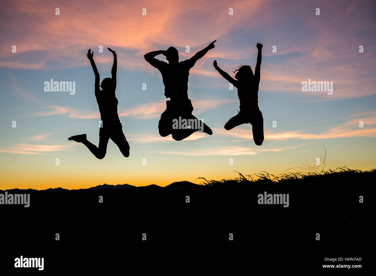 Silhouette of friends jumping for joy at sunset Stock Photo - Alamy