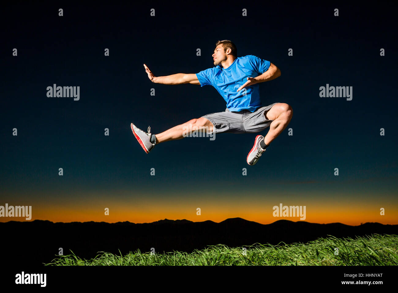 Caucasian man jumping at sunset Stock Photo - Alamy
