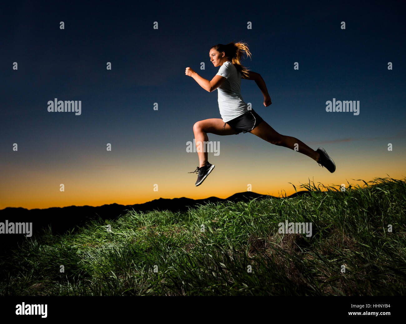 Caucasian woman running at sunset Stock Photo - Alamy