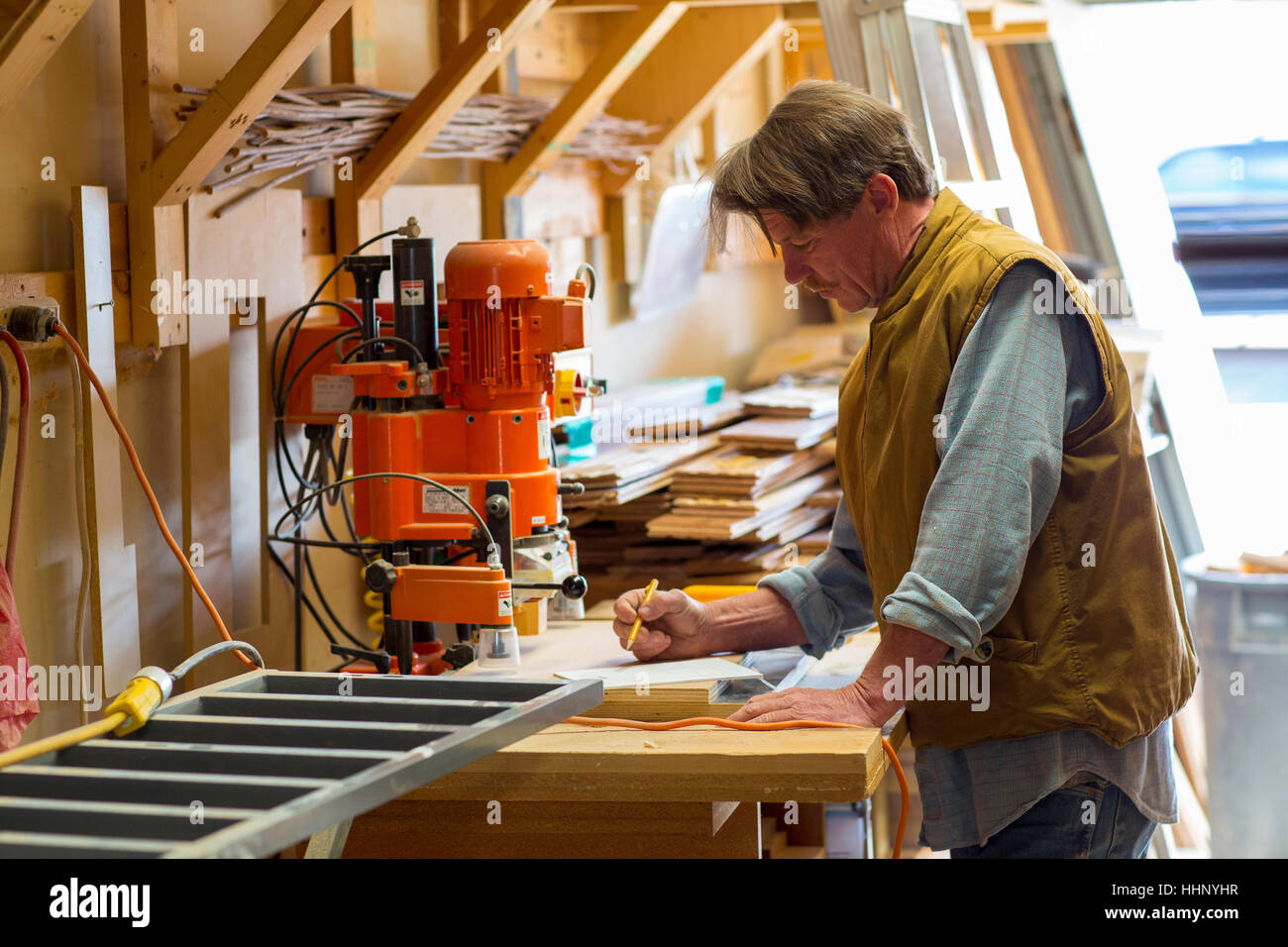 Caucasian carpenter writing on notepad in workshop Stock Photo - Alamy