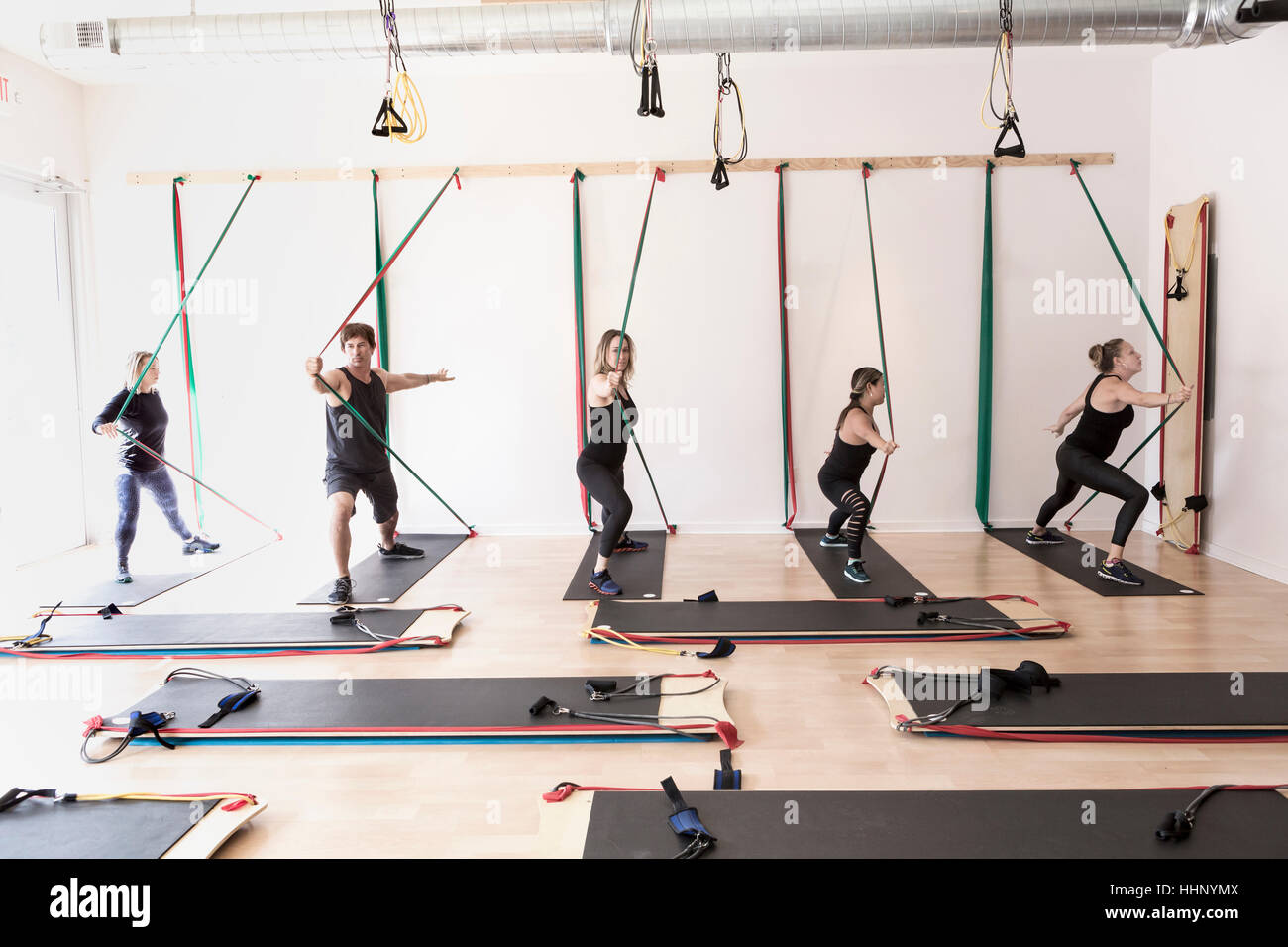 People pushing on resistance bands in gymnasium Stock Photo - Alamy