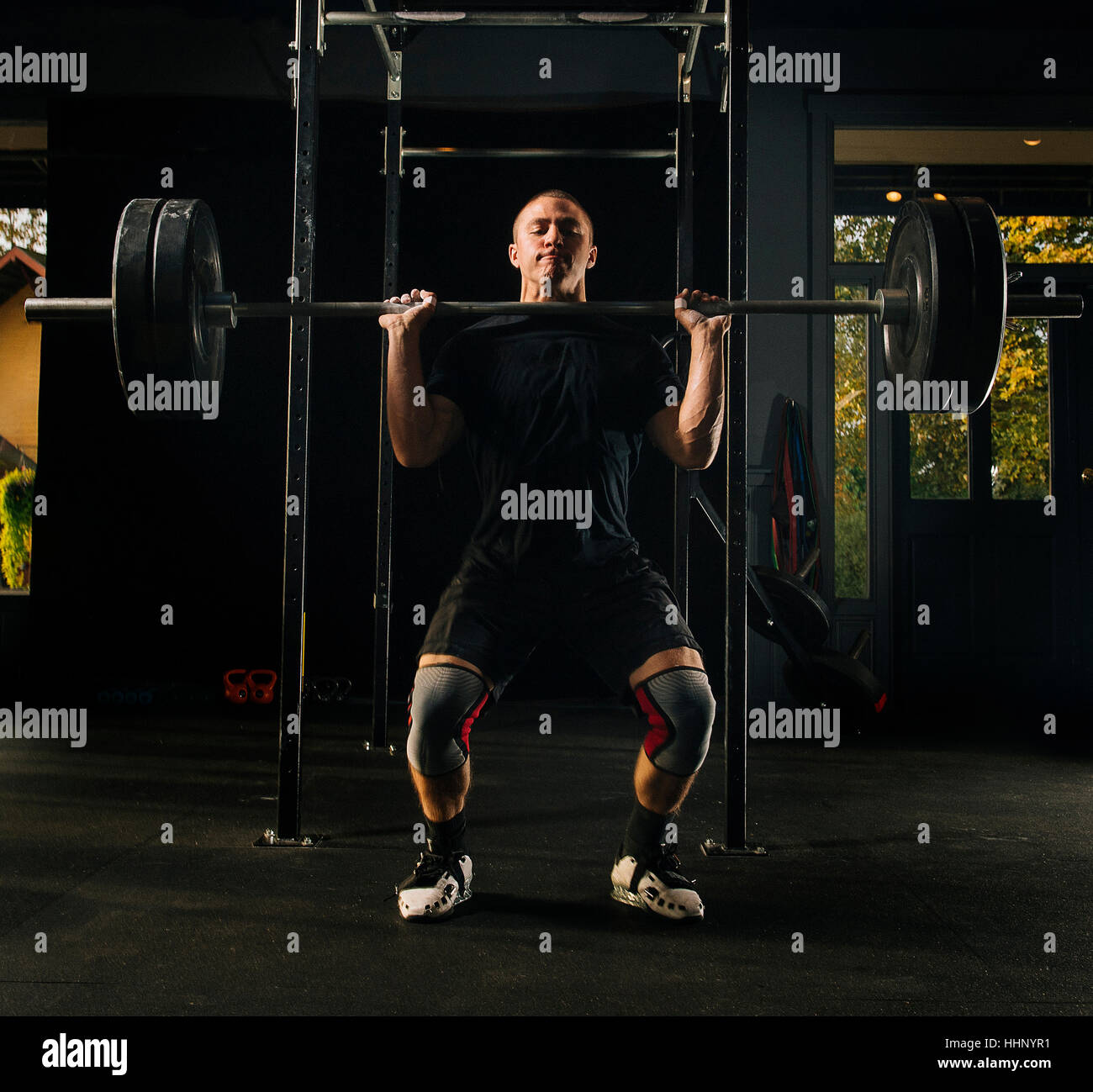 Man lifting heavy barbell in gymnasium Stock Photo - Alamy