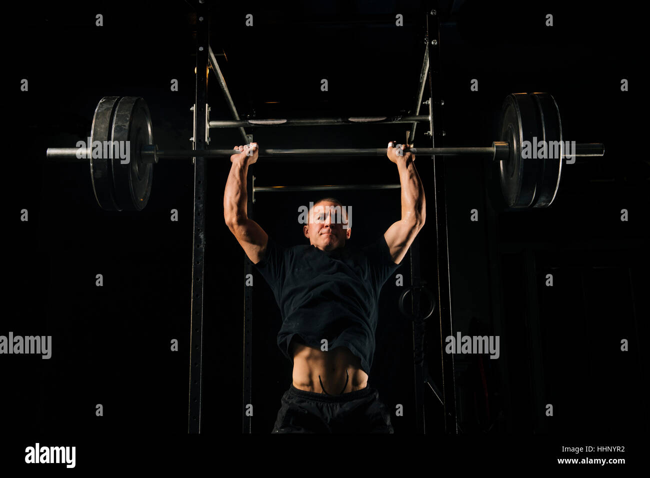Man lifting heavy barbell in gymnasium Stock Photo - Alamy