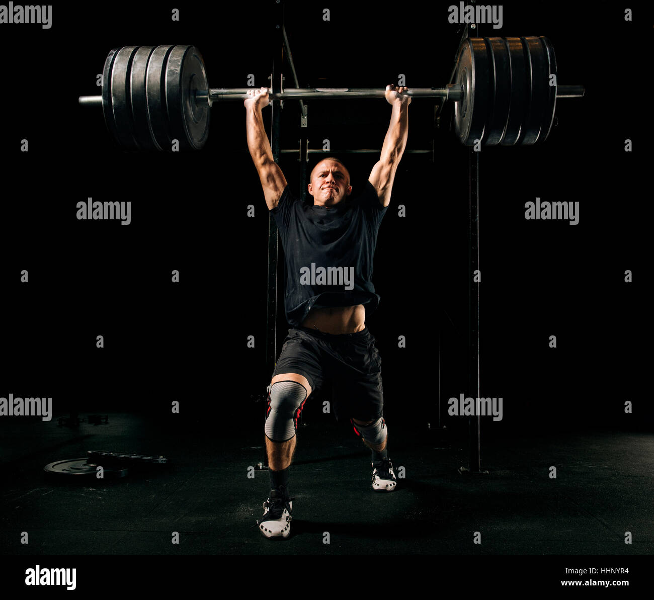 Man lifting heavy barbell in gymnasium Stock Photo - Alamy