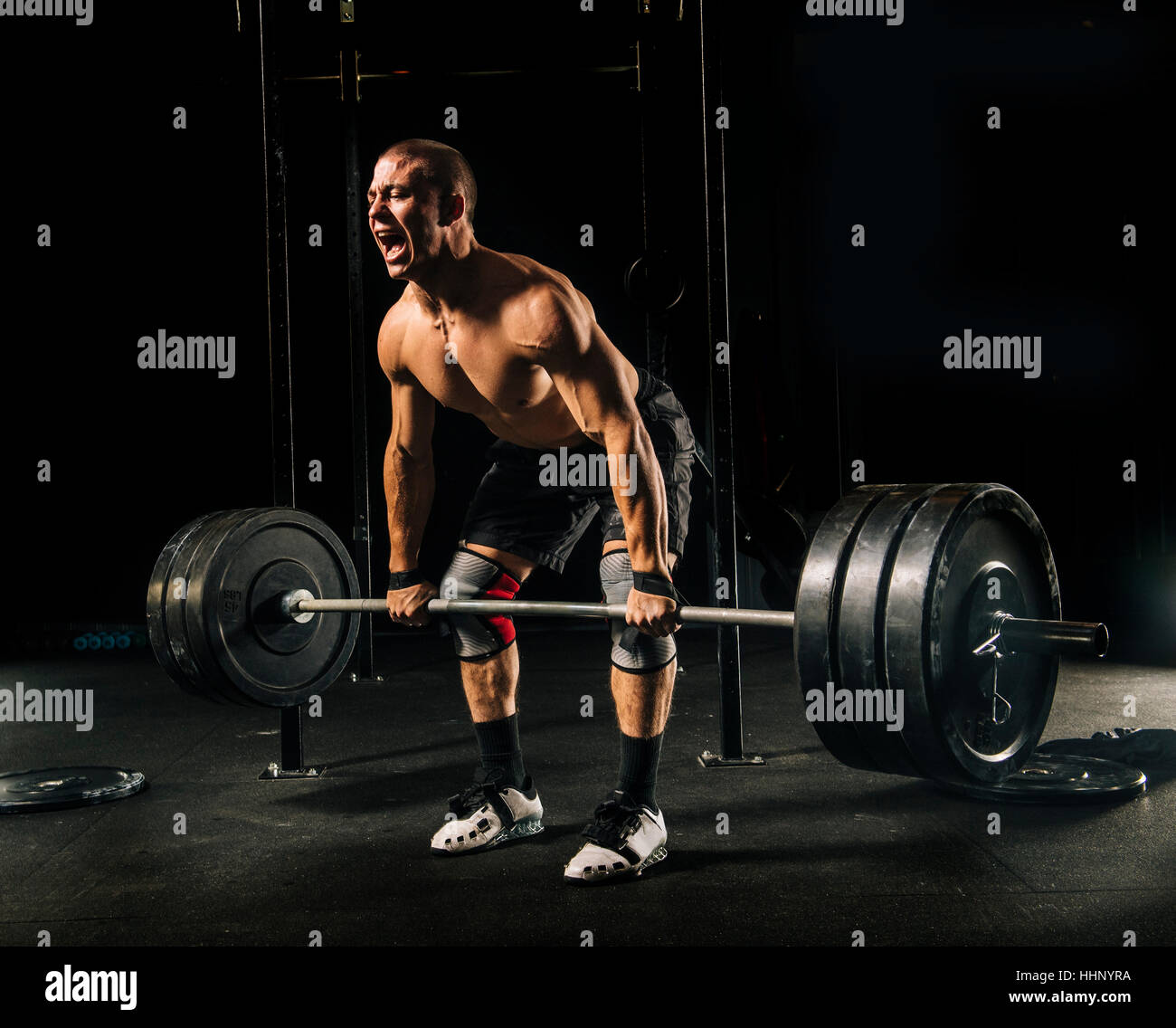 Man screaming while lifting heavy barbell in gymnasium Stock Photo - Alamy