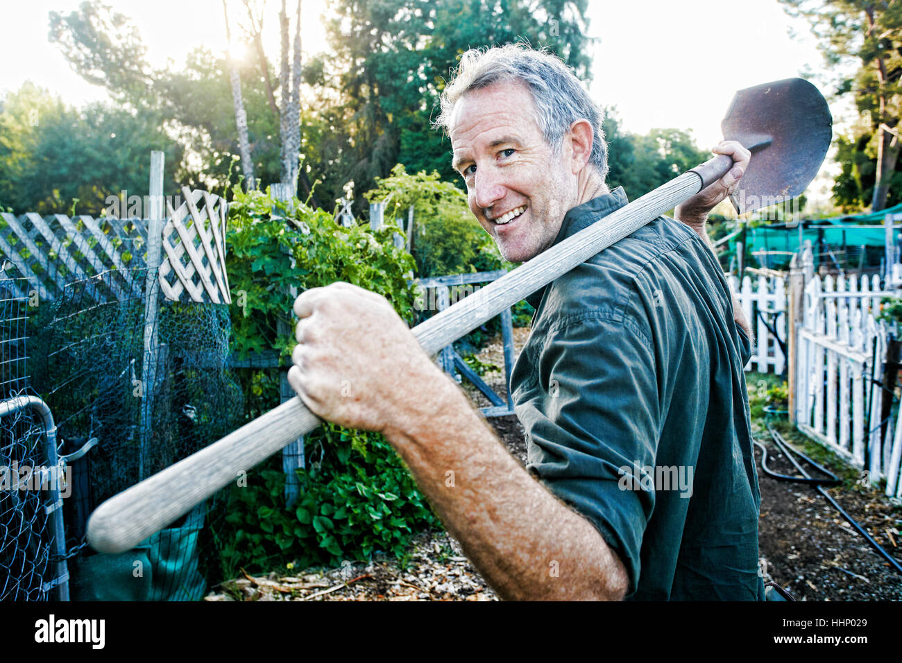 Portrait of Caucasian man carrying shovel in garden Stock Photo - Alamy