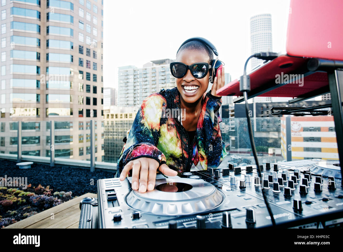 Smiling Black DJ on urban rooftop Stock Photo - Alamy