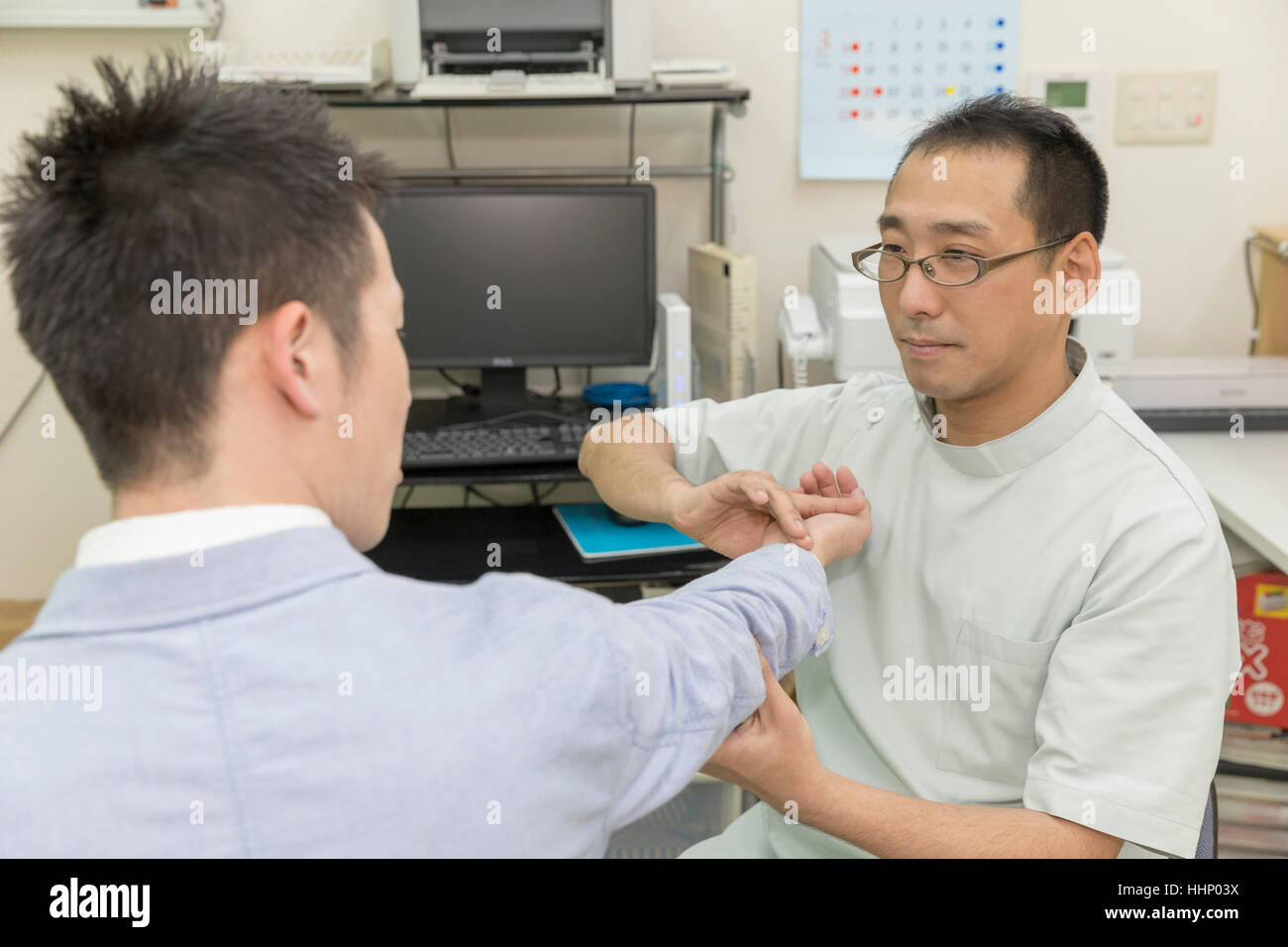 Doctor Manipulating the Arms of A Man Stock Photo - Alamy