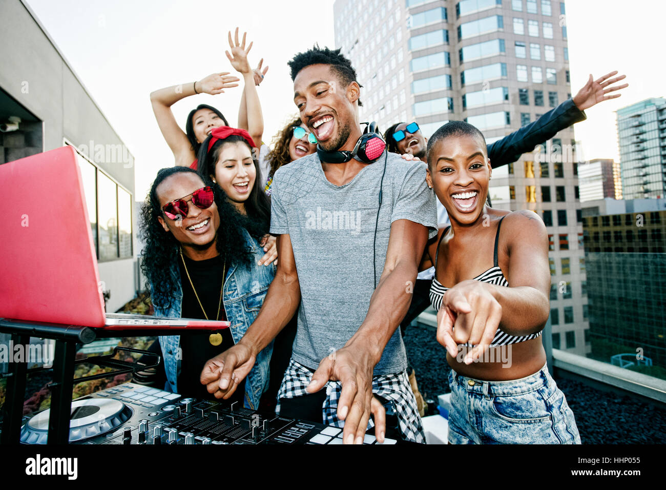 Friends posing with DJ on urban rooftop Stock Photo - Alamy