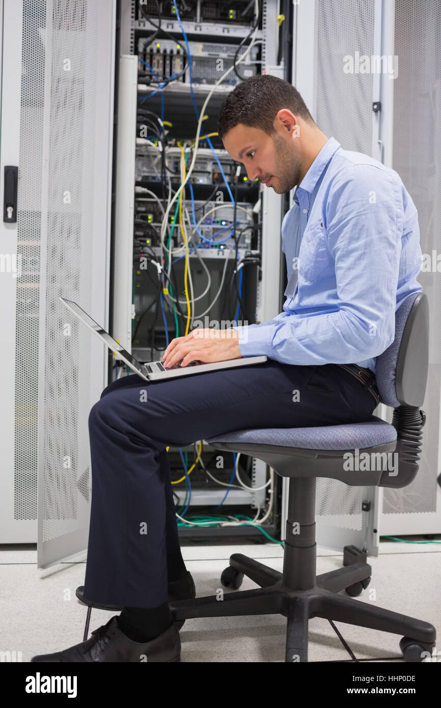 Man on his laptop beside servers in data center Stock Photo - Alamy