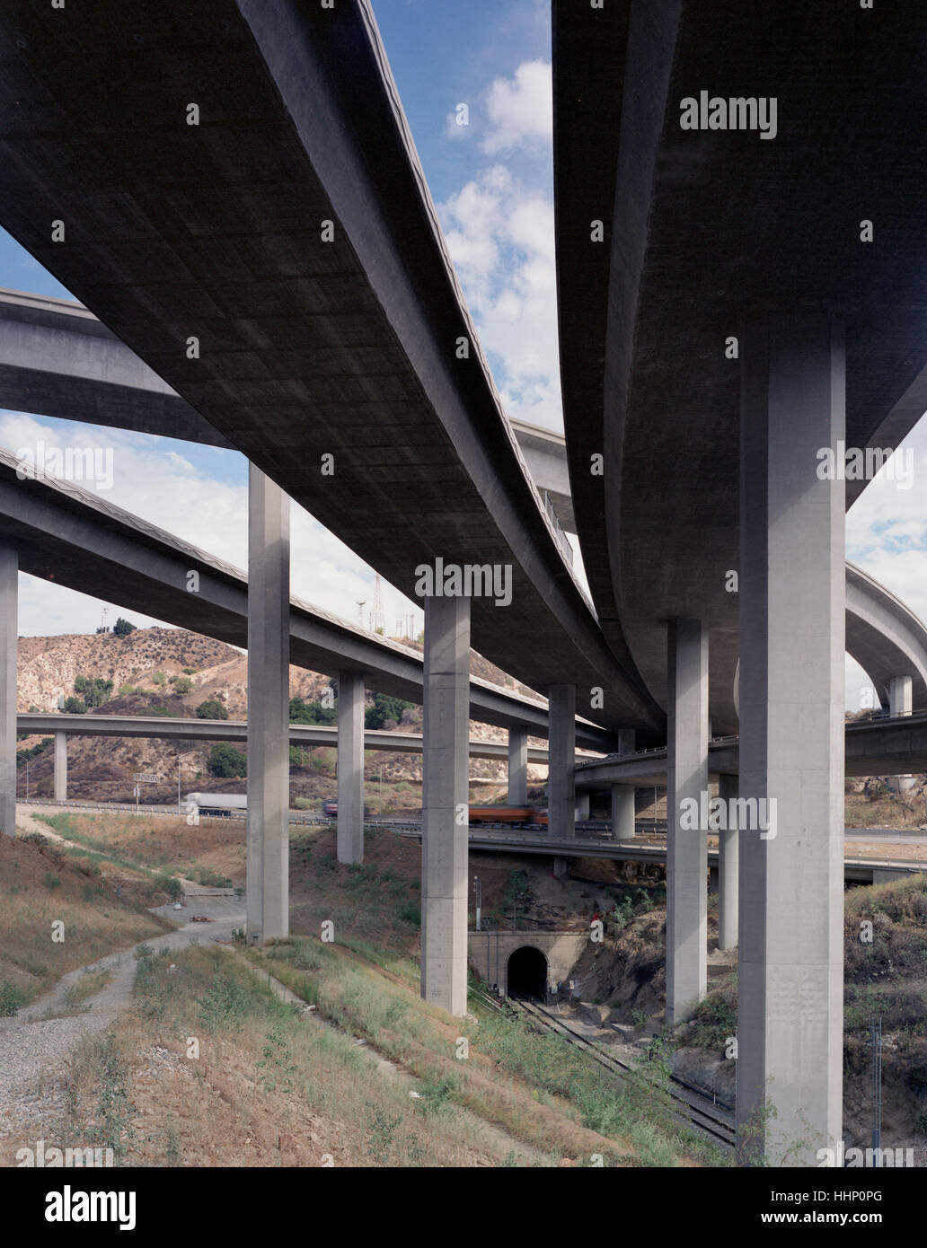 Trucks and cars driving under freeway overpass Stock Photo - Alamy