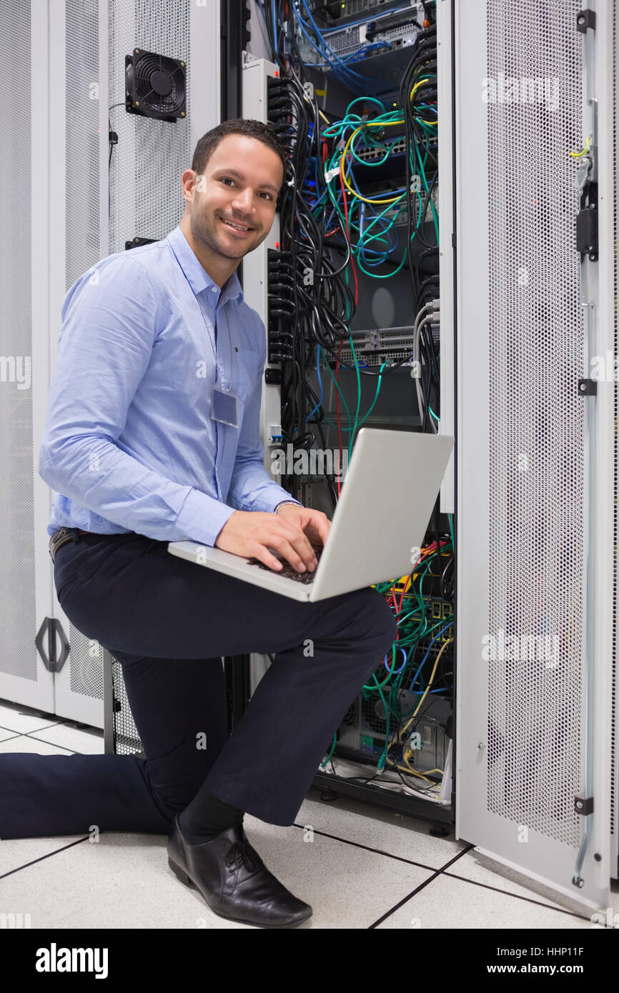 Man doing maintenance at the data store with laptop Stock Photo - Alamy