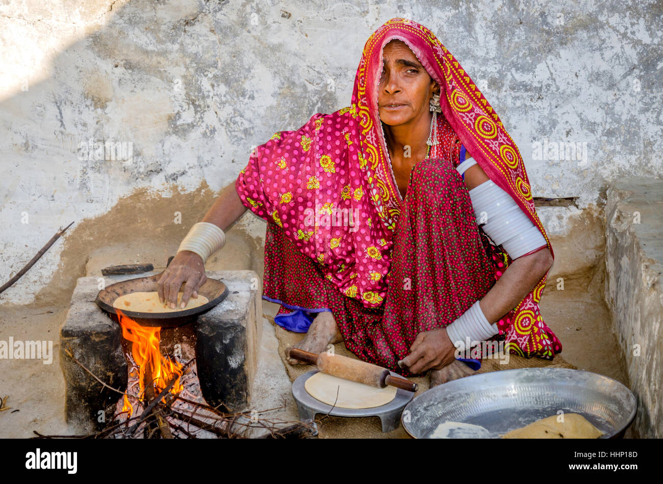 Woman cooking food on firewood Stock Photo - Alamy