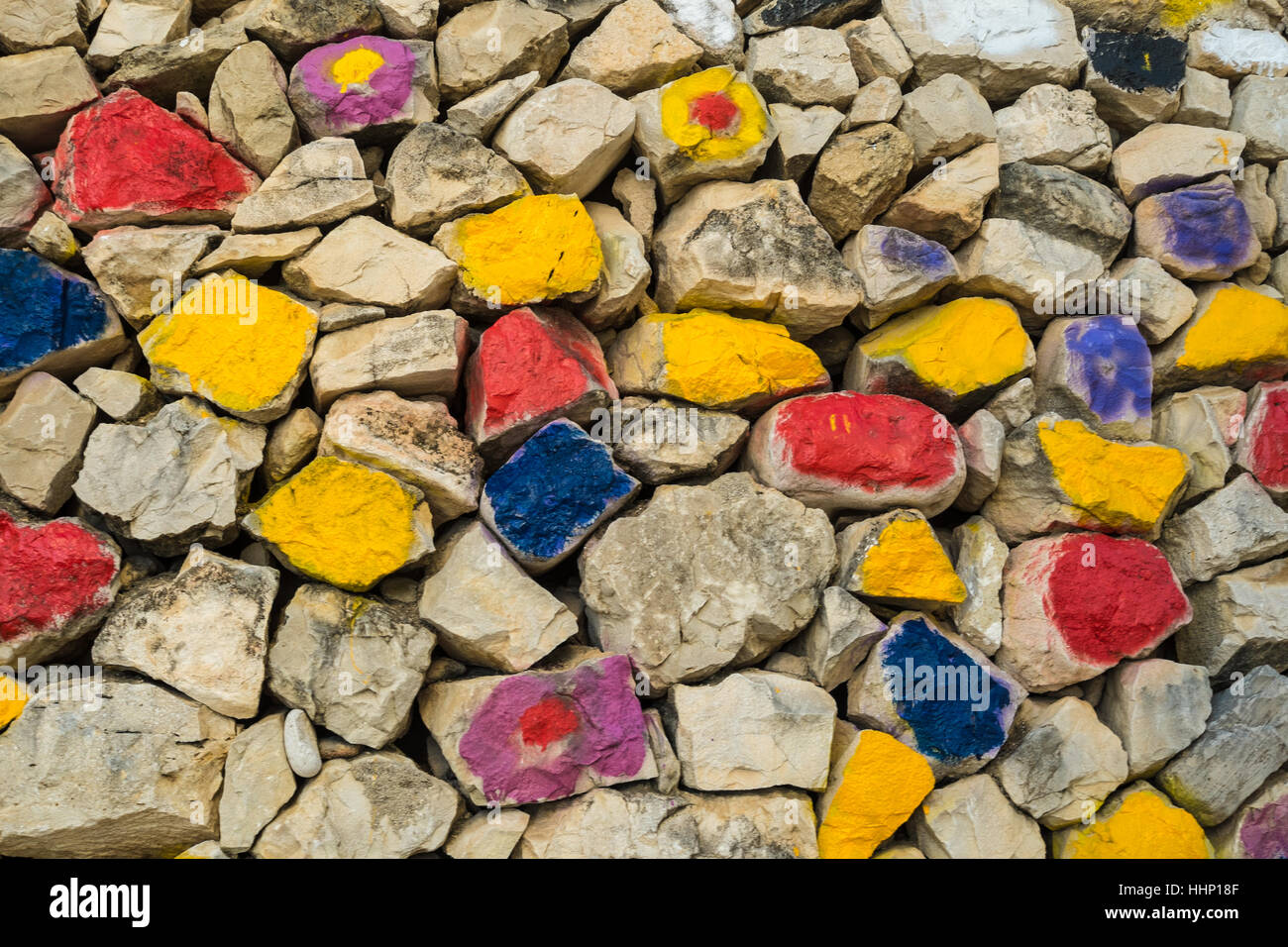 Masonry wall with artistically colored stones Stock Photo - Alamy