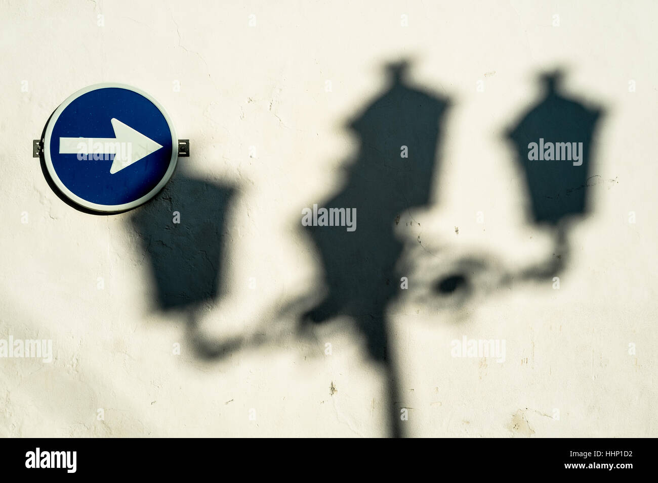 Traffic sign on a whitewashed wall with the shade of large street ...