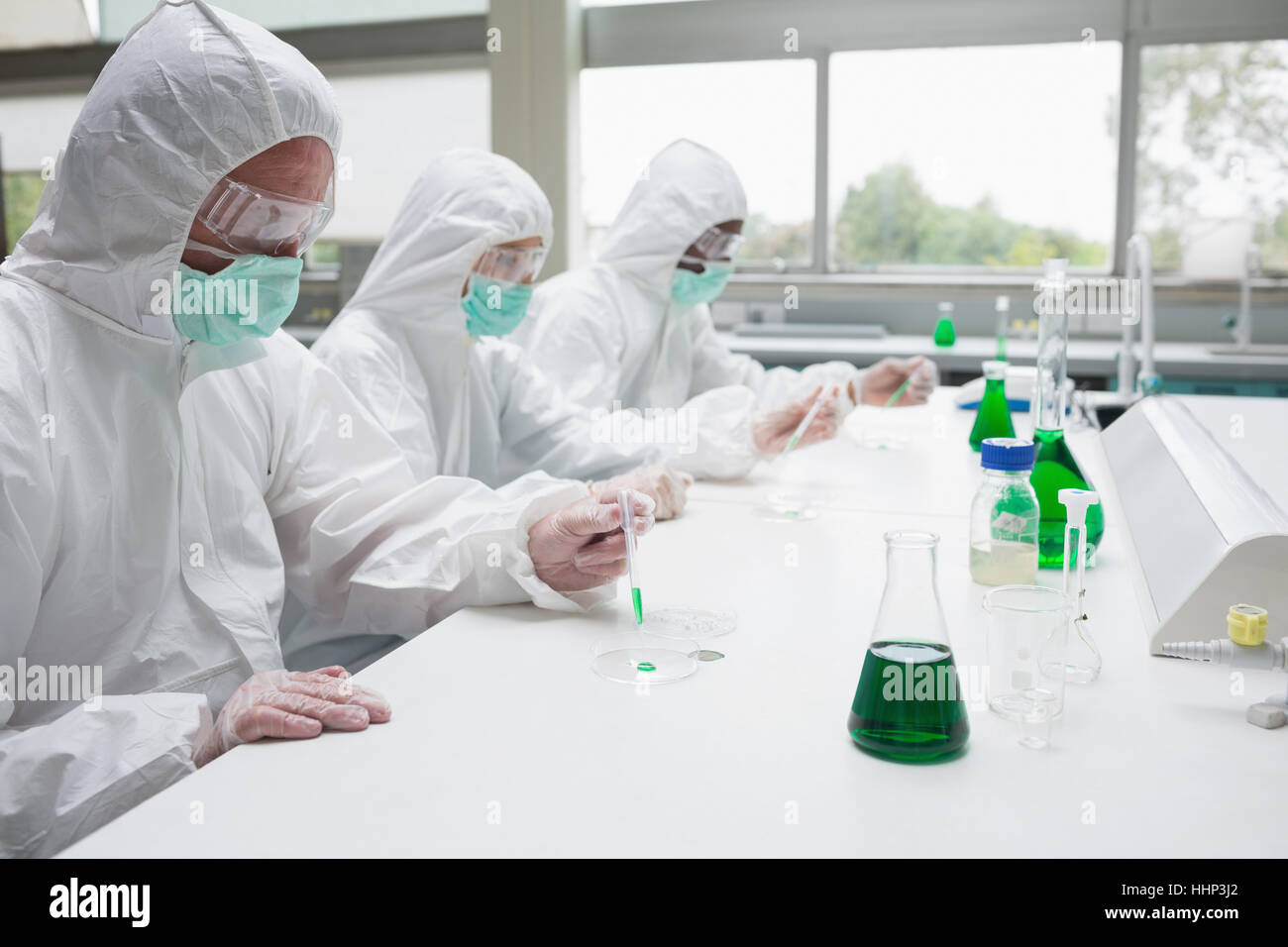 Testing in white suits hi-res stock photography and images - Alamy